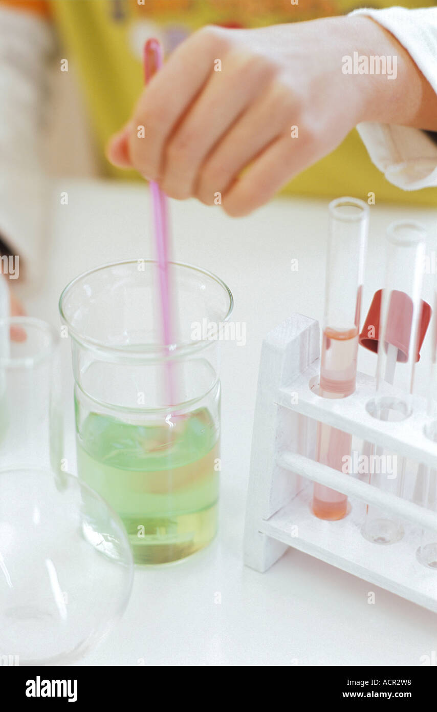 Human hand holding pipette in beaker, elevated view Stock Photo - Alamy
