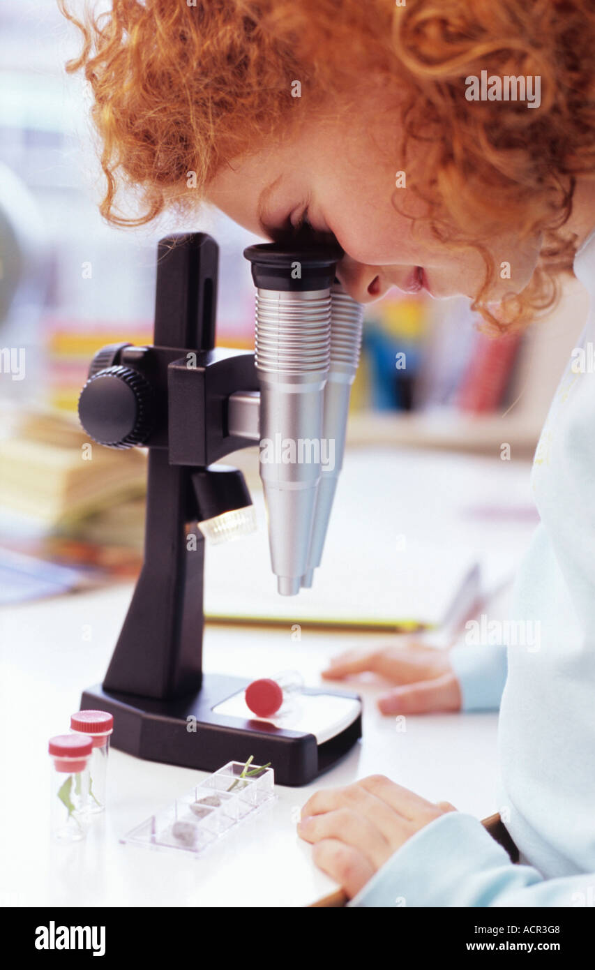 Girl (8-9) using microscope Stock Photo - Alamy