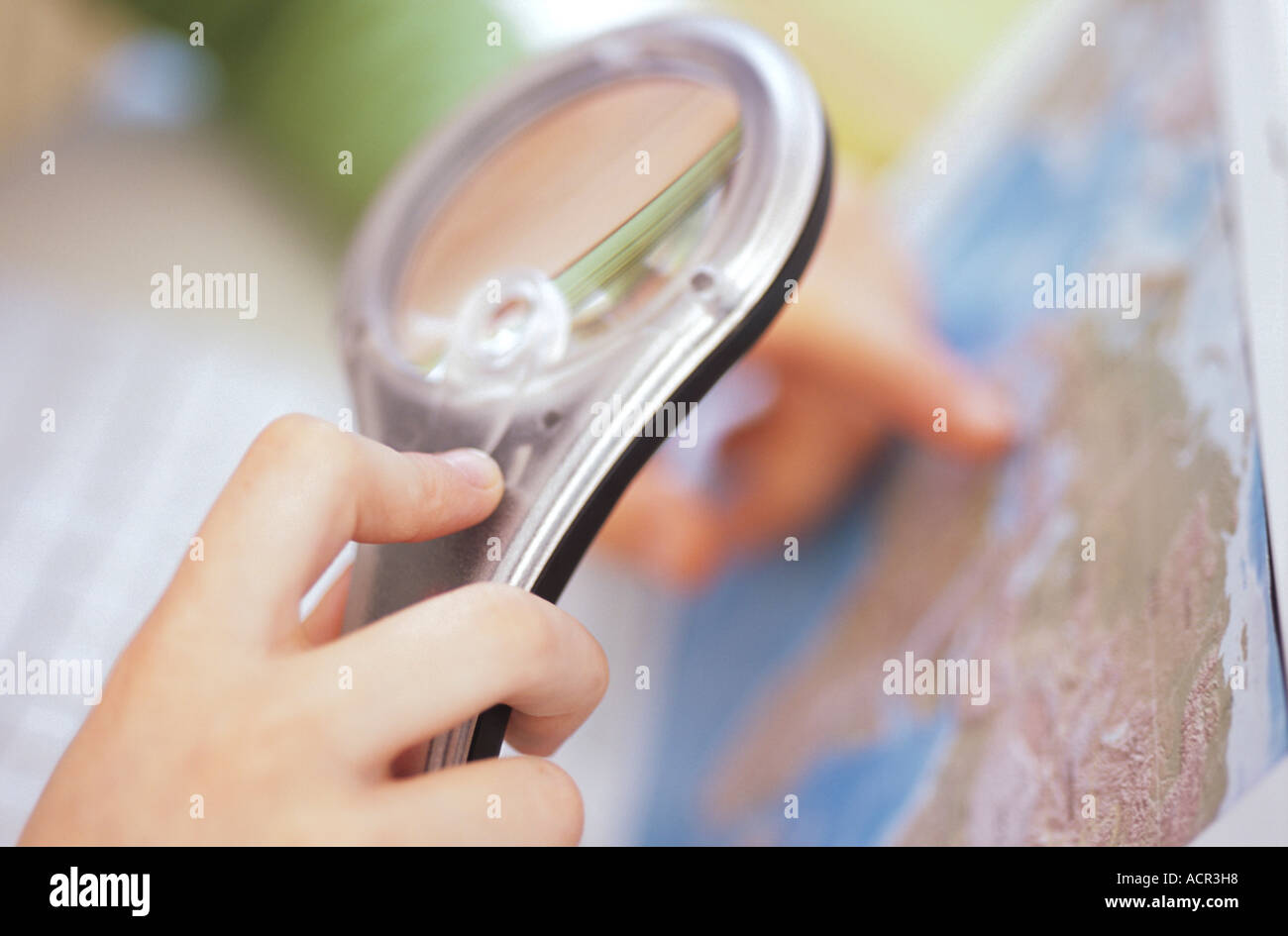 Child looking at map with magnifying glass Stock Photo - Alamy