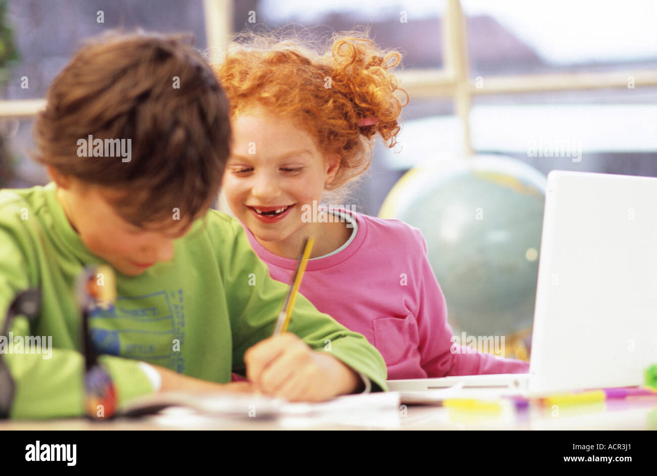 Boy and girl (7-9) using laptop, writing Stock Photo - Alamy