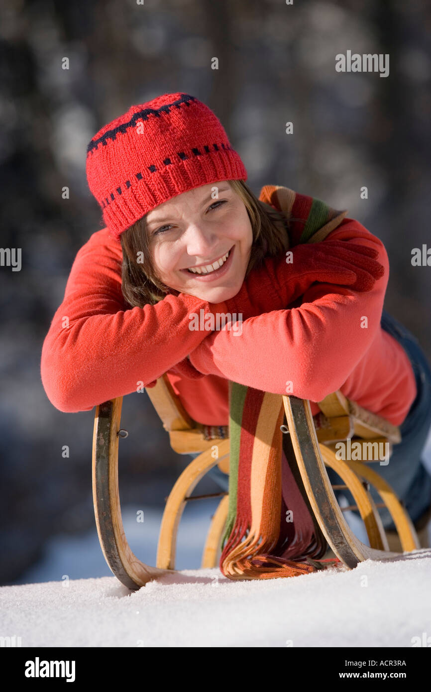 Young woman lying on sledge, portrait, smiling Stock Photo - Alamy