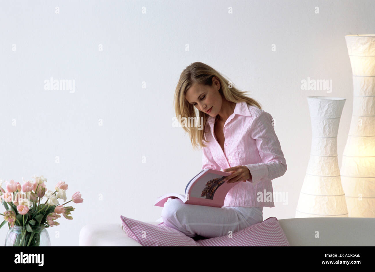 Young woman reading magazine, side view Stock Photo - Alamy