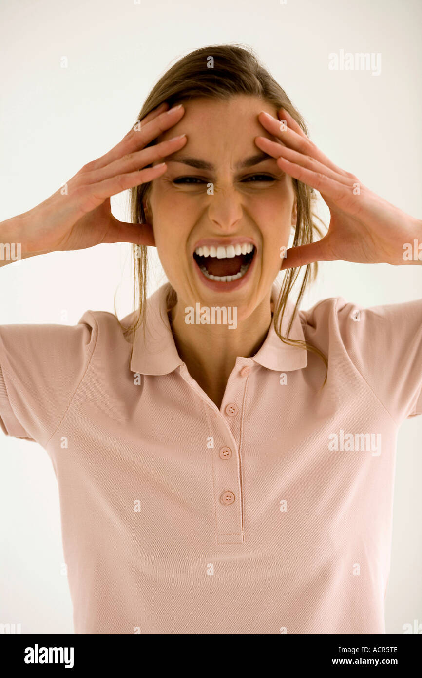 Young woman with head in hands, shouting, close-up Stock Photo - Alamy
