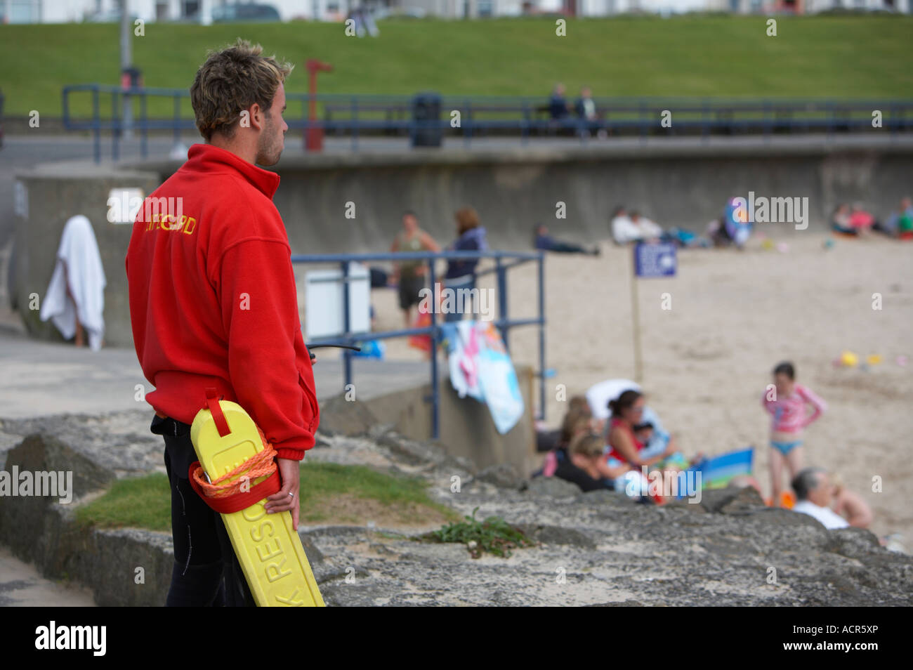 male surf rescue lifeguard watching over the beach and families at ...