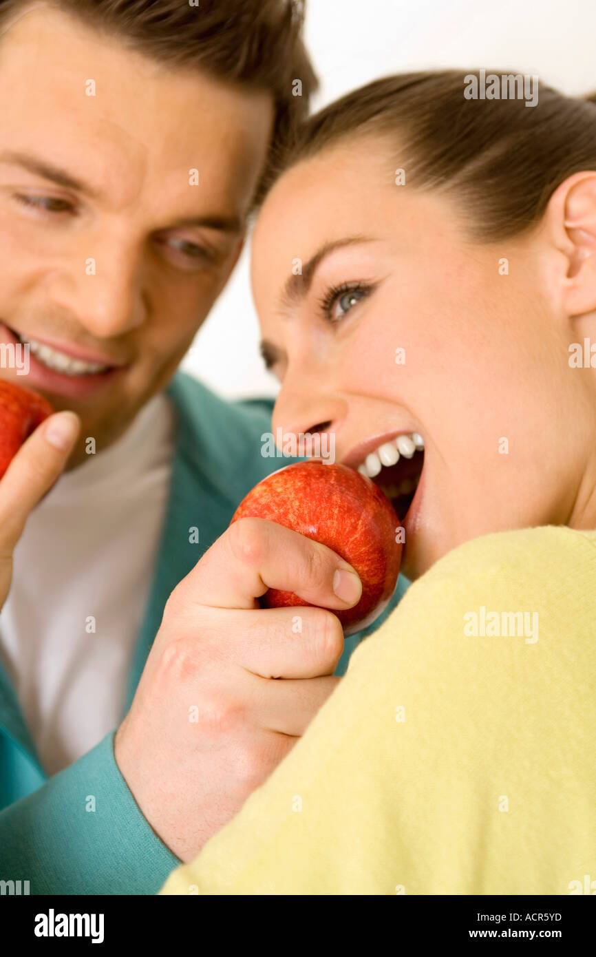 Man and woman eating red apple Stock Photo - Alamy