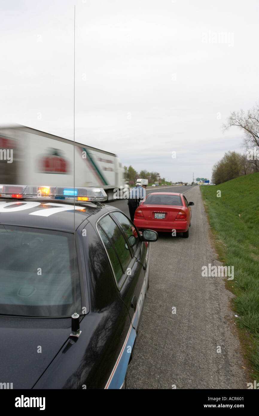 Police conducting traffic stop in high-traffic area. Cars and trucks ...
