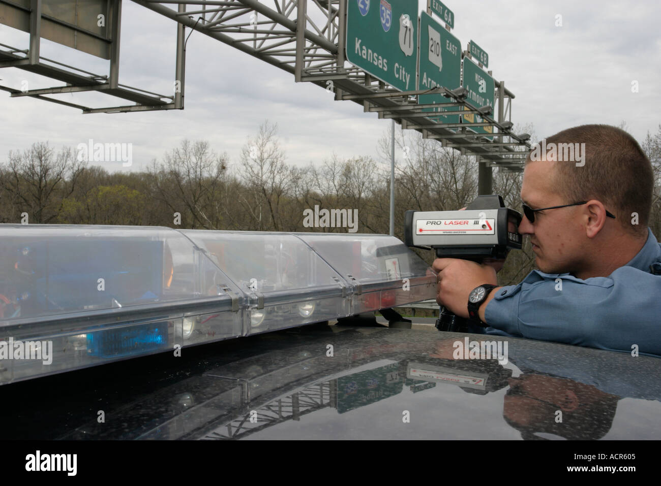 Police officer using hand-held laser to measure the speed of oncoming ...