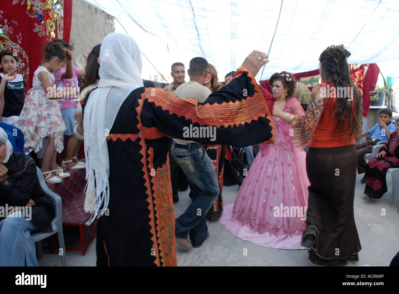 Wedding guests, family, and bride dance at a Palestinian wedding in ...