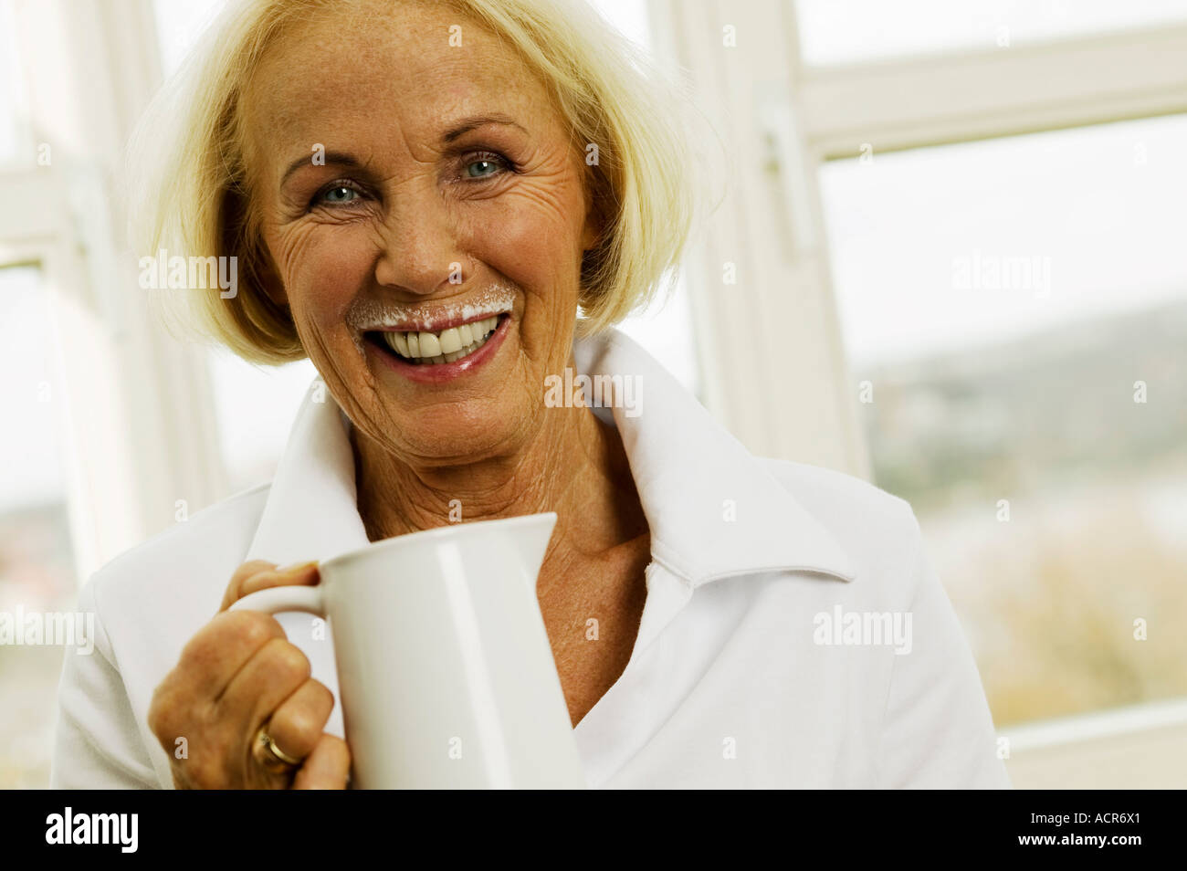Senior woman holding milk jug, smiling, portrait, close-up Stock Photo ...