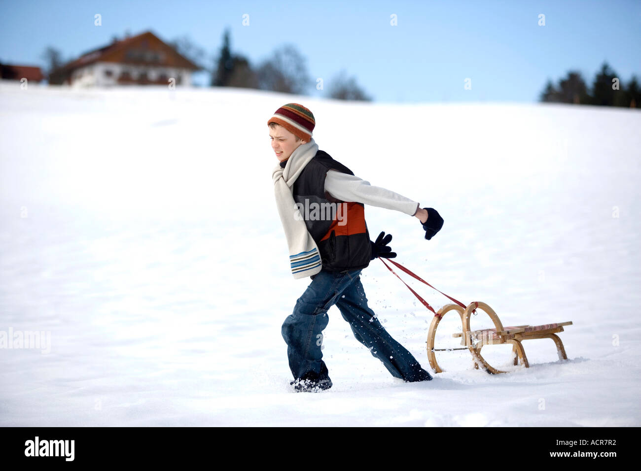 Austria, boy (12-13) pulling sledge in snow, side view Stock Photo - Alamy