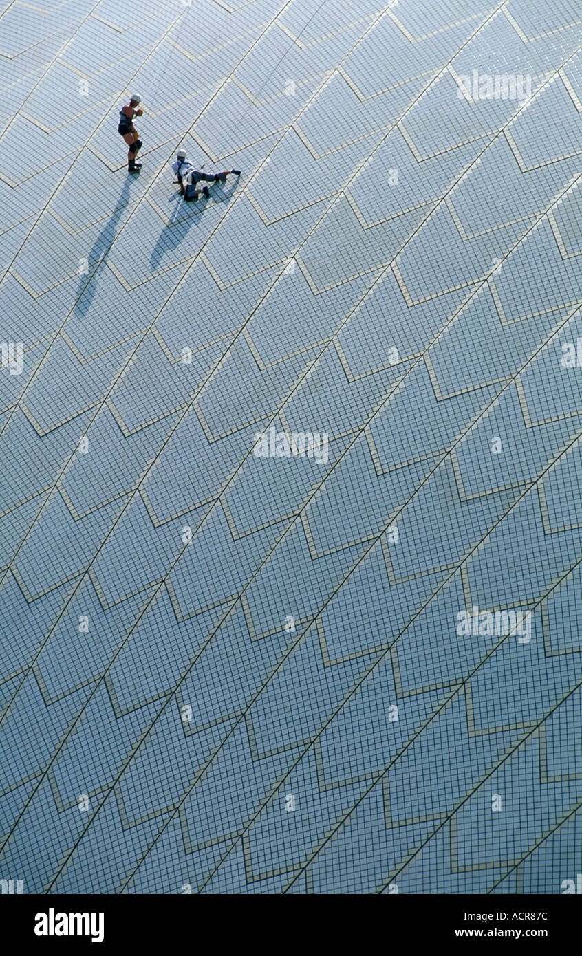 Acrobatic Figures abseiling down the roof of the tiled Sydney Opera ...