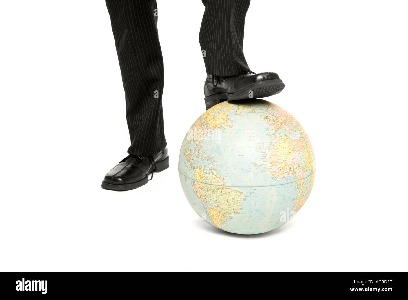 A businessman rests his foot on a blobe Stock Photo - Alamy