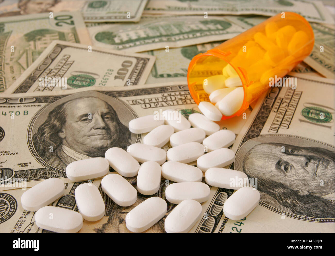 Prescription pills spilling on hundred dollar bank notes with shallow ...