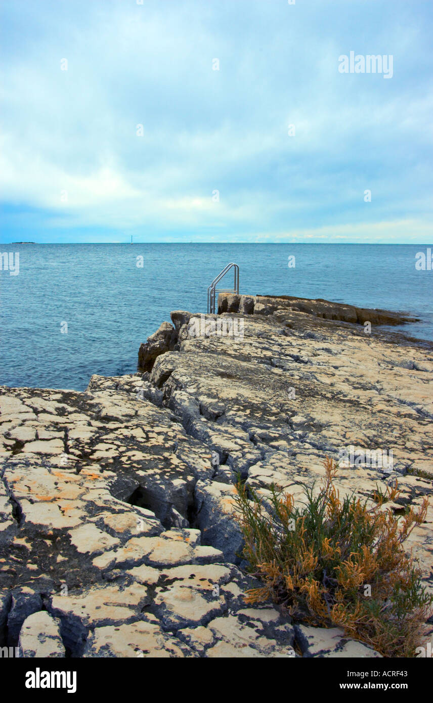 Water access steps and handrail for sea swimmers on rocky shore Stock ...