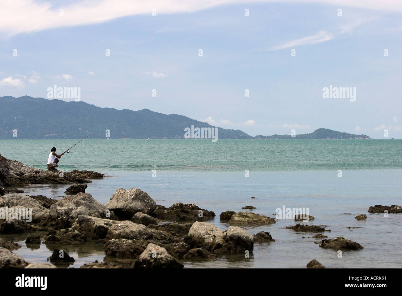Man fishing with rod from rocks Mae Nam beach Ko Samui Thailand Stock ...