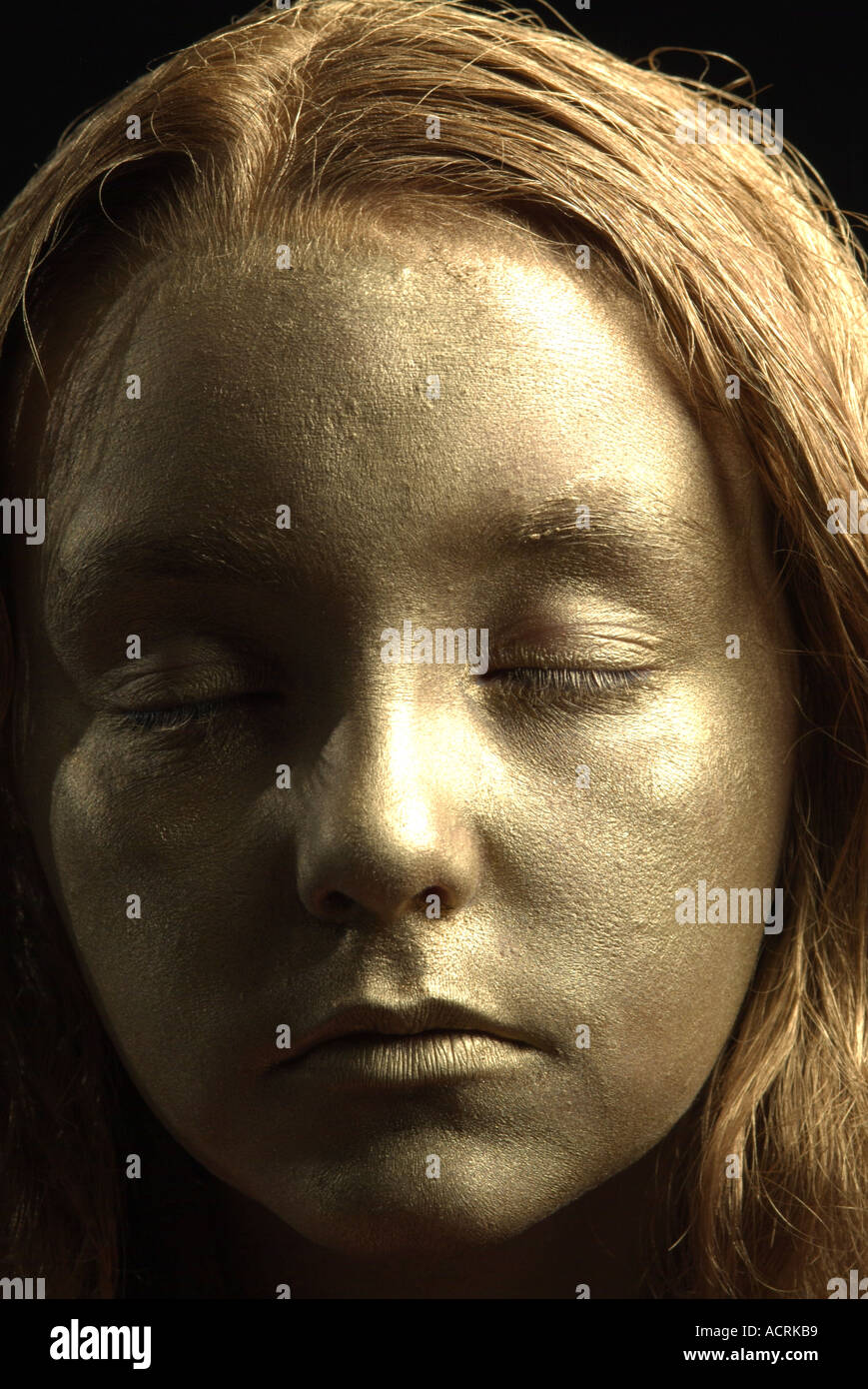 gold face girl with half face shadowed eyes closed no smile sad Stock ...