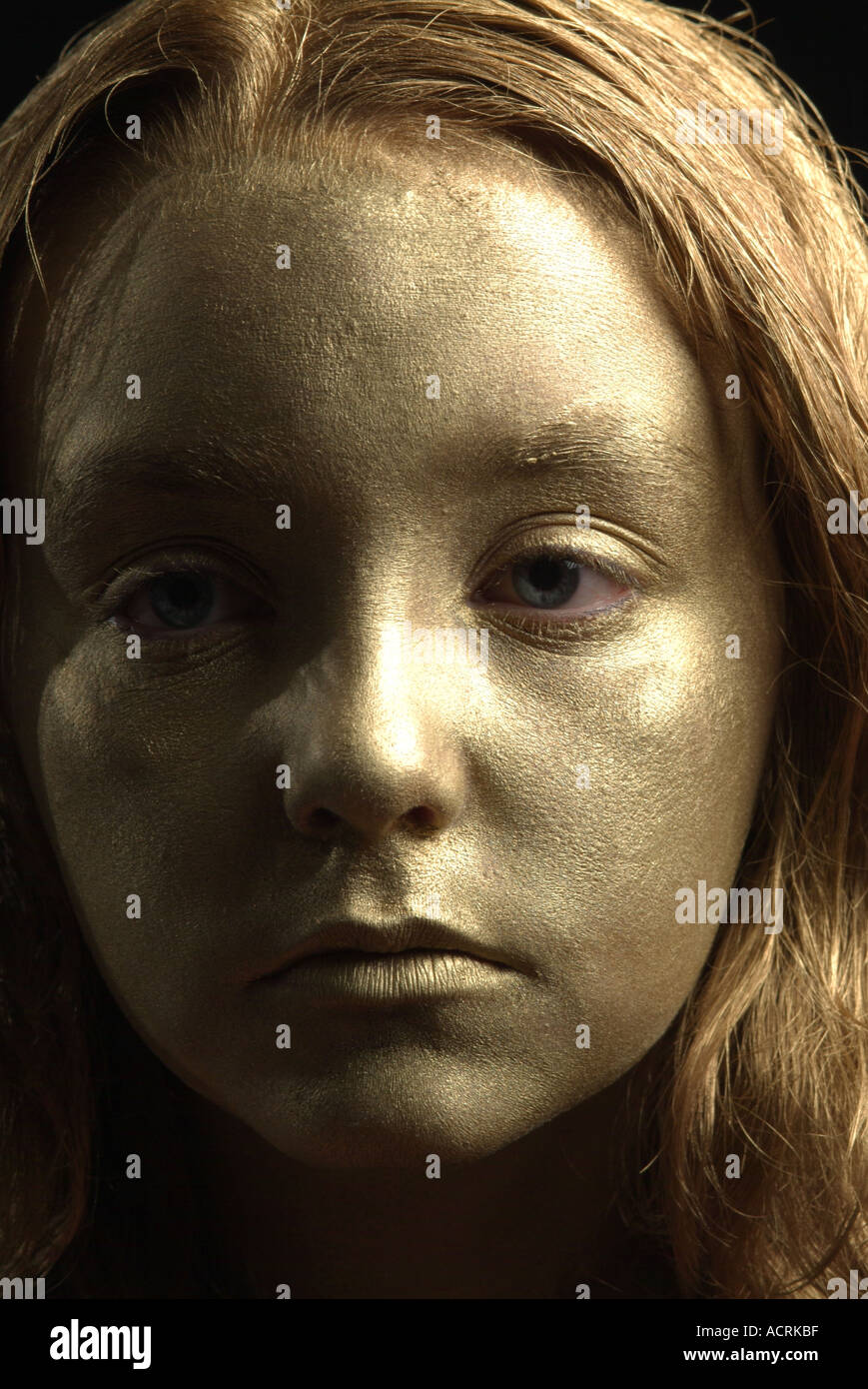 gold face girl with half face shadowed eyes closed smile sad Stock ...