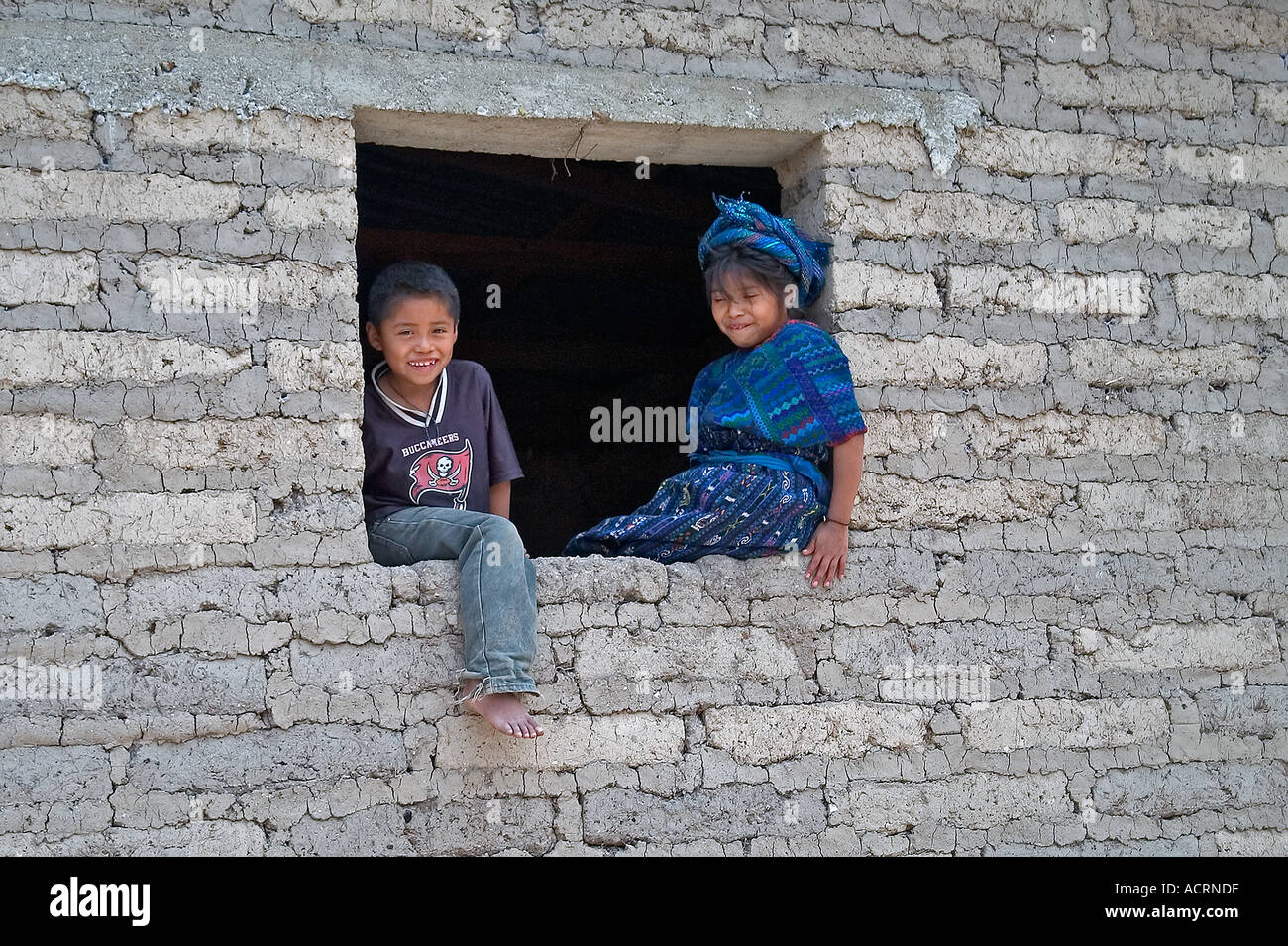 Mayan children sit in a window opening in Santa Maria Guatemala Stock ...