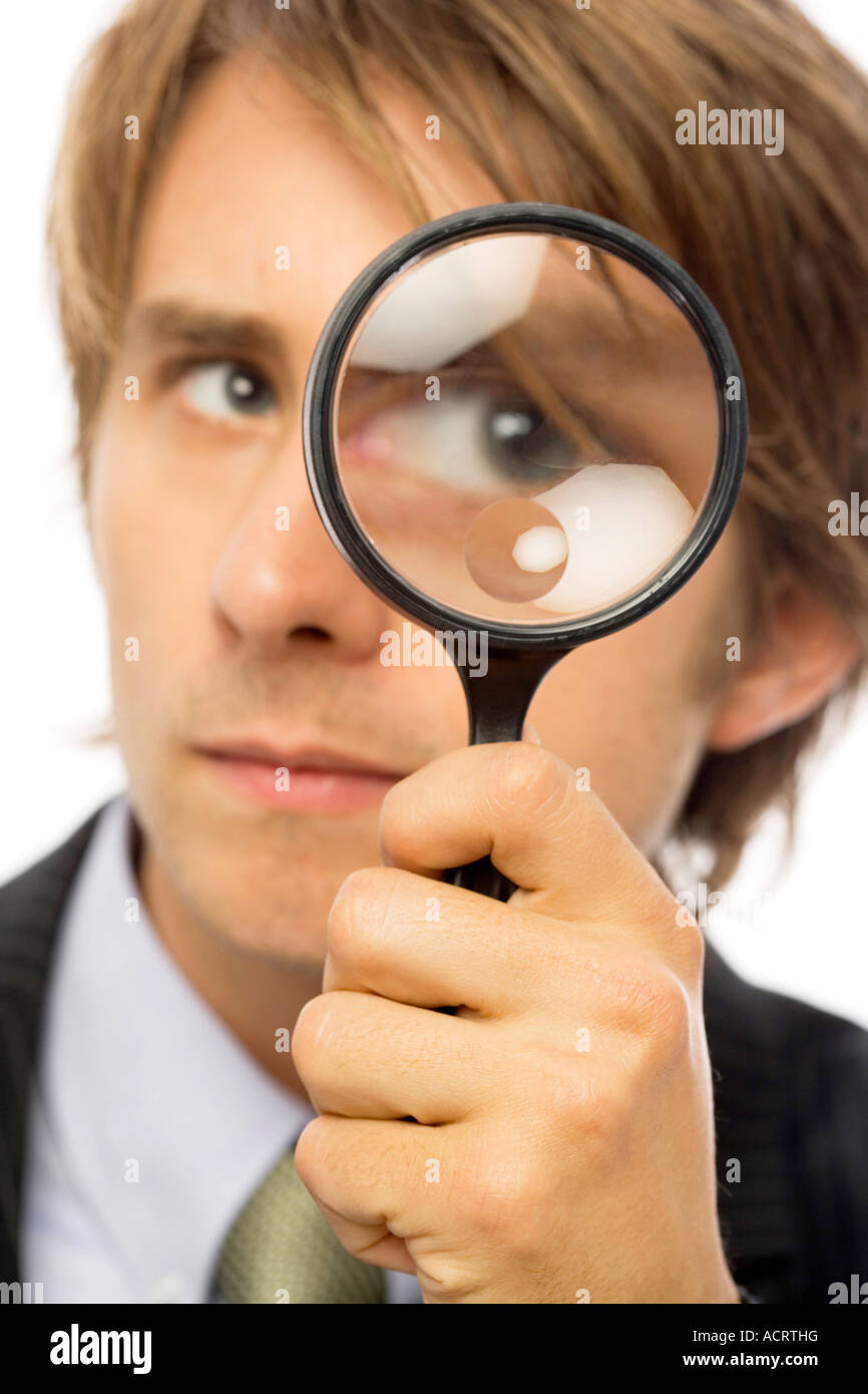 Businessman in a suit looks through a magnifying glass Stock Photo - Alamy