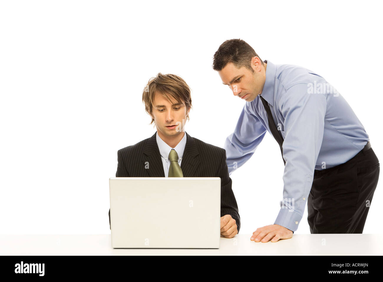 Businessmen talk while using a laptop computer Stock Photo - Alamy