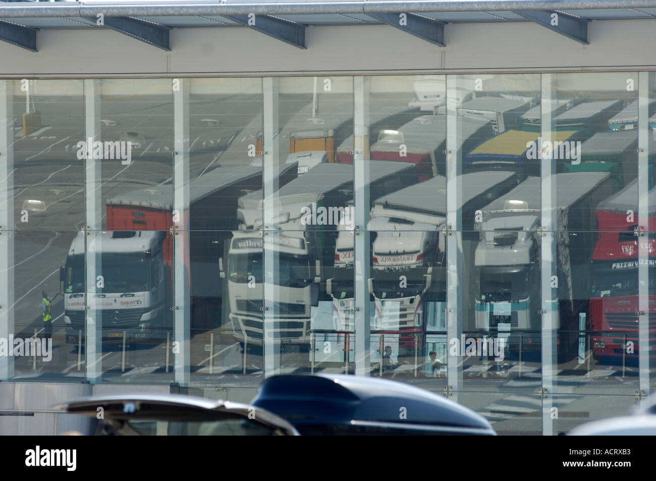Lorries trucks reflectin in glass facade at the ferry port Dover Kent ...
