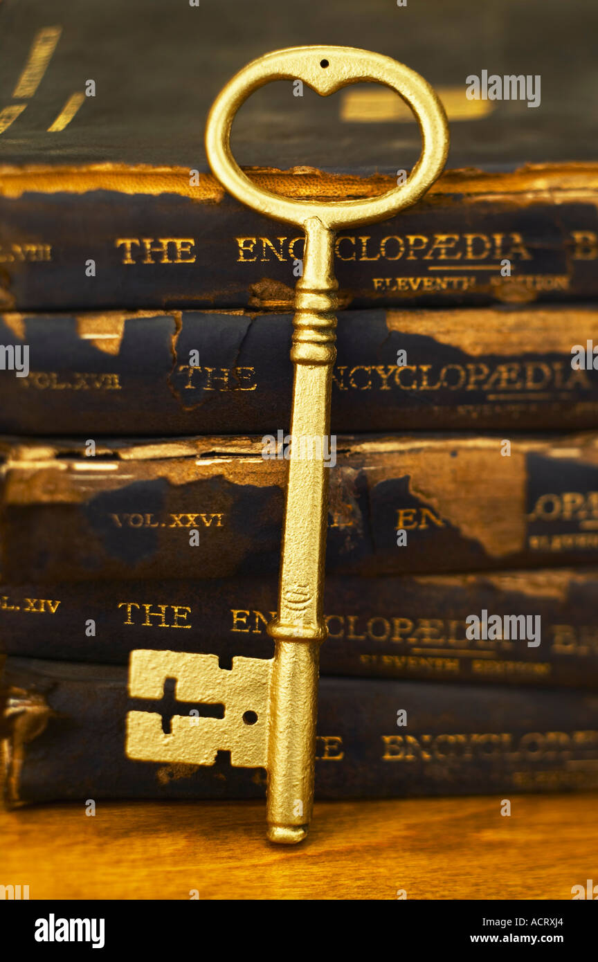 Gold key and stack of old books Stock Photo - Alamy