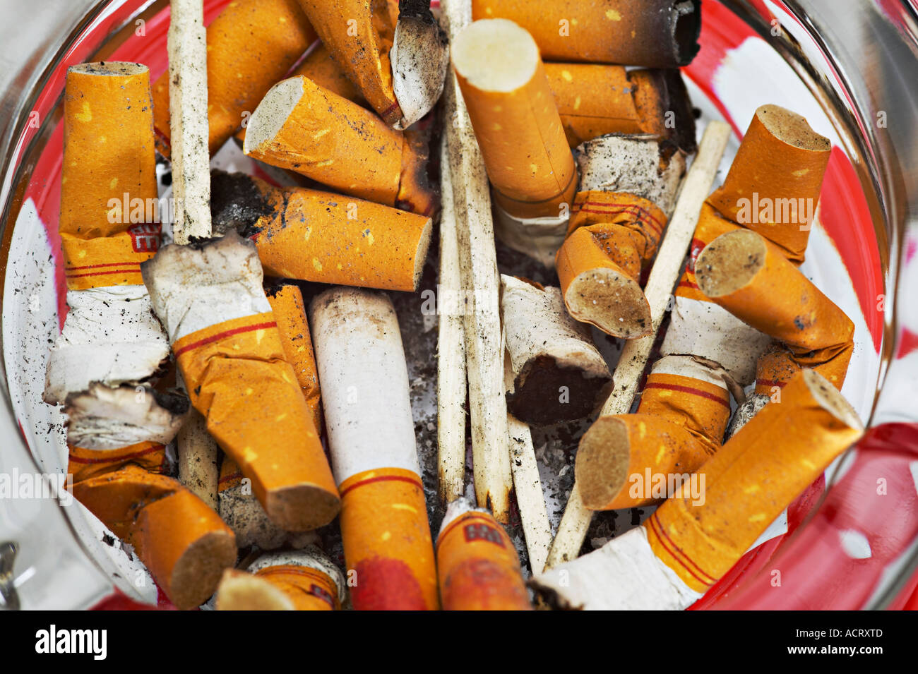 Ashtray filled with cigarette butts and burnt matches Stock Photo - Alamy