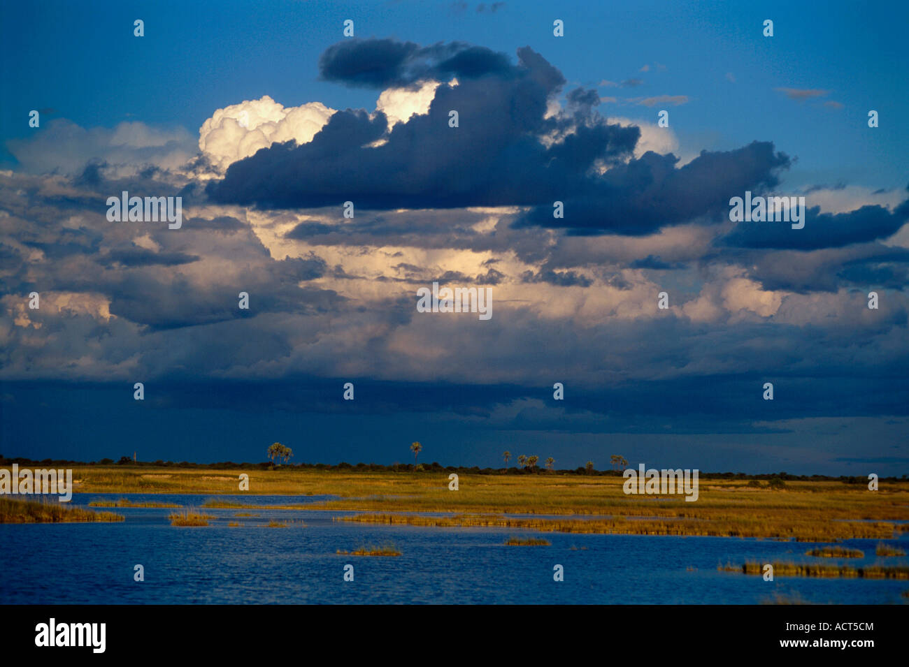 Scenic view of a flooded pan against dark storm clouds in Botswana ...
