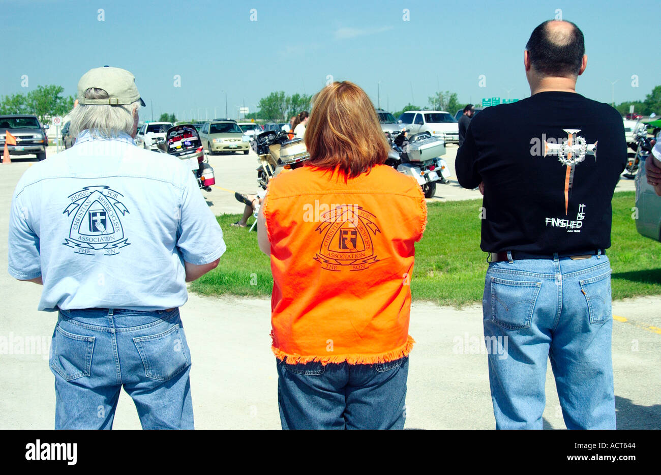 Christian motorcycle club emblems on the backs of three participants ...