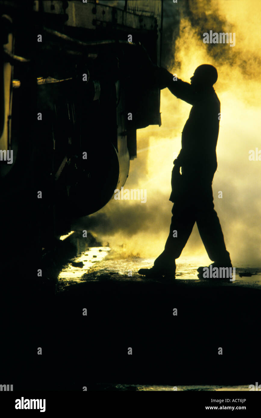 A railway mechanic busy with routine maintenance tasks on a steaming ...