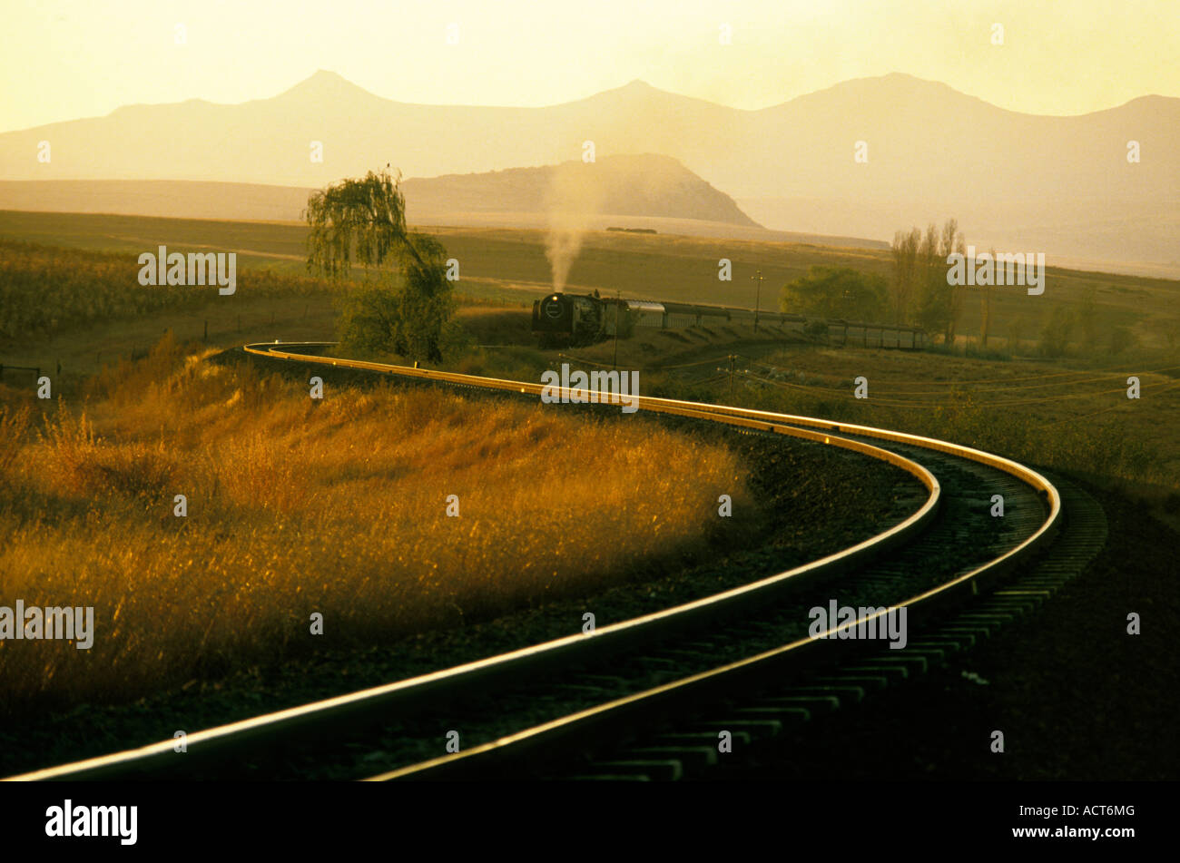 A train approaching on a railway line winding through remote ...