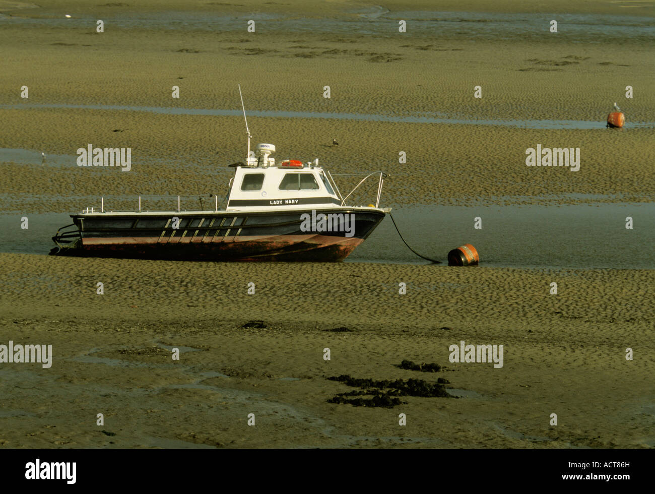 A boat beached on sand at low tide England Stock Photo - Alamy