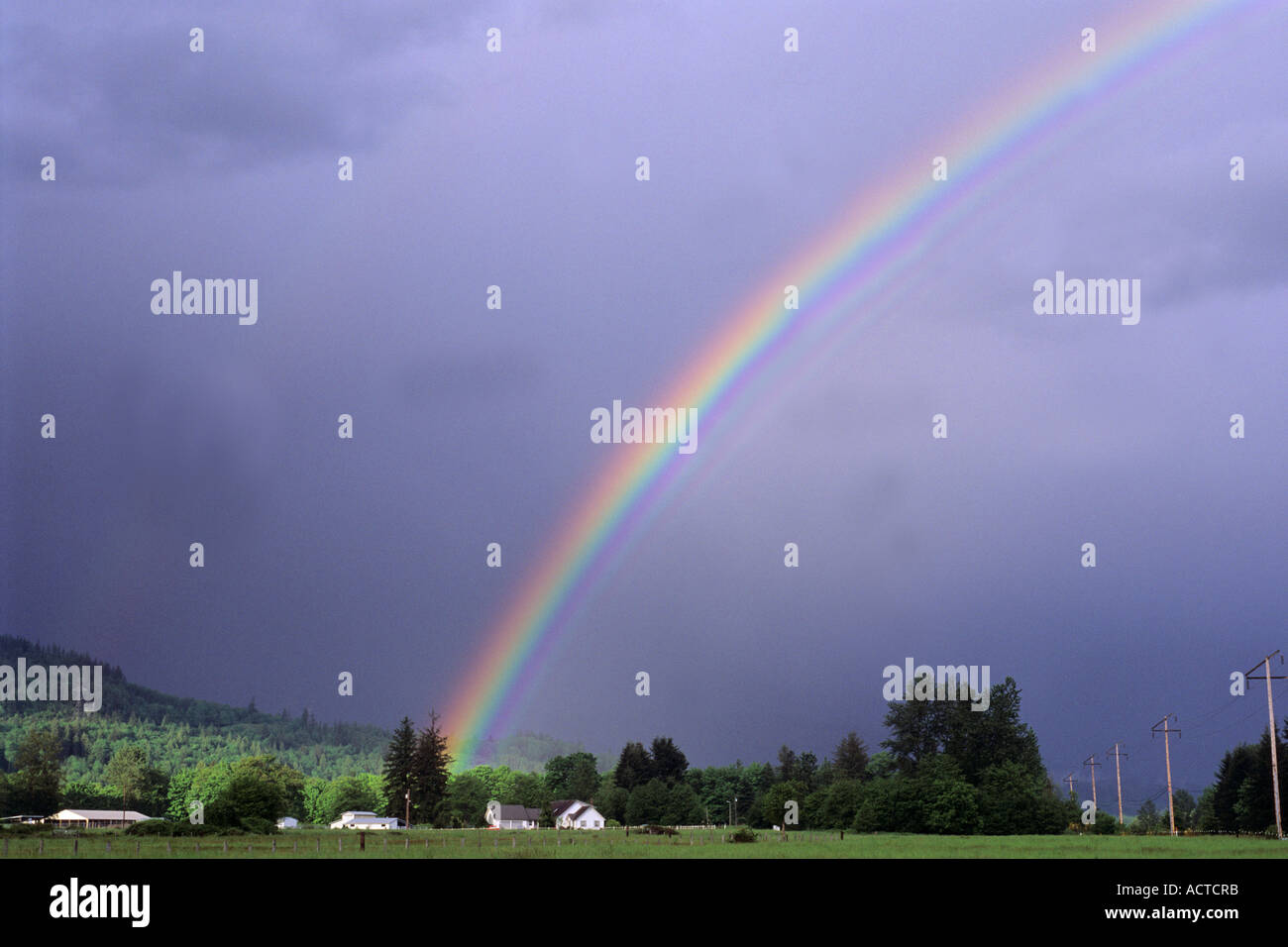 Rainbow over field and farm, Cascade Mountains, Washington Stock Photo ...