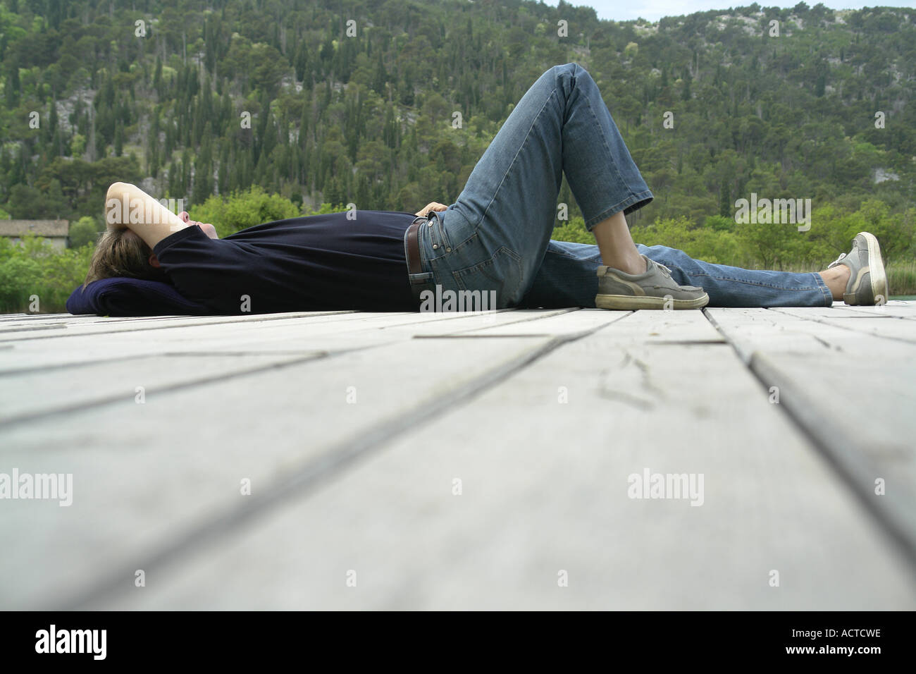 Man lay down on wooden floor Stock Photo - Alamy