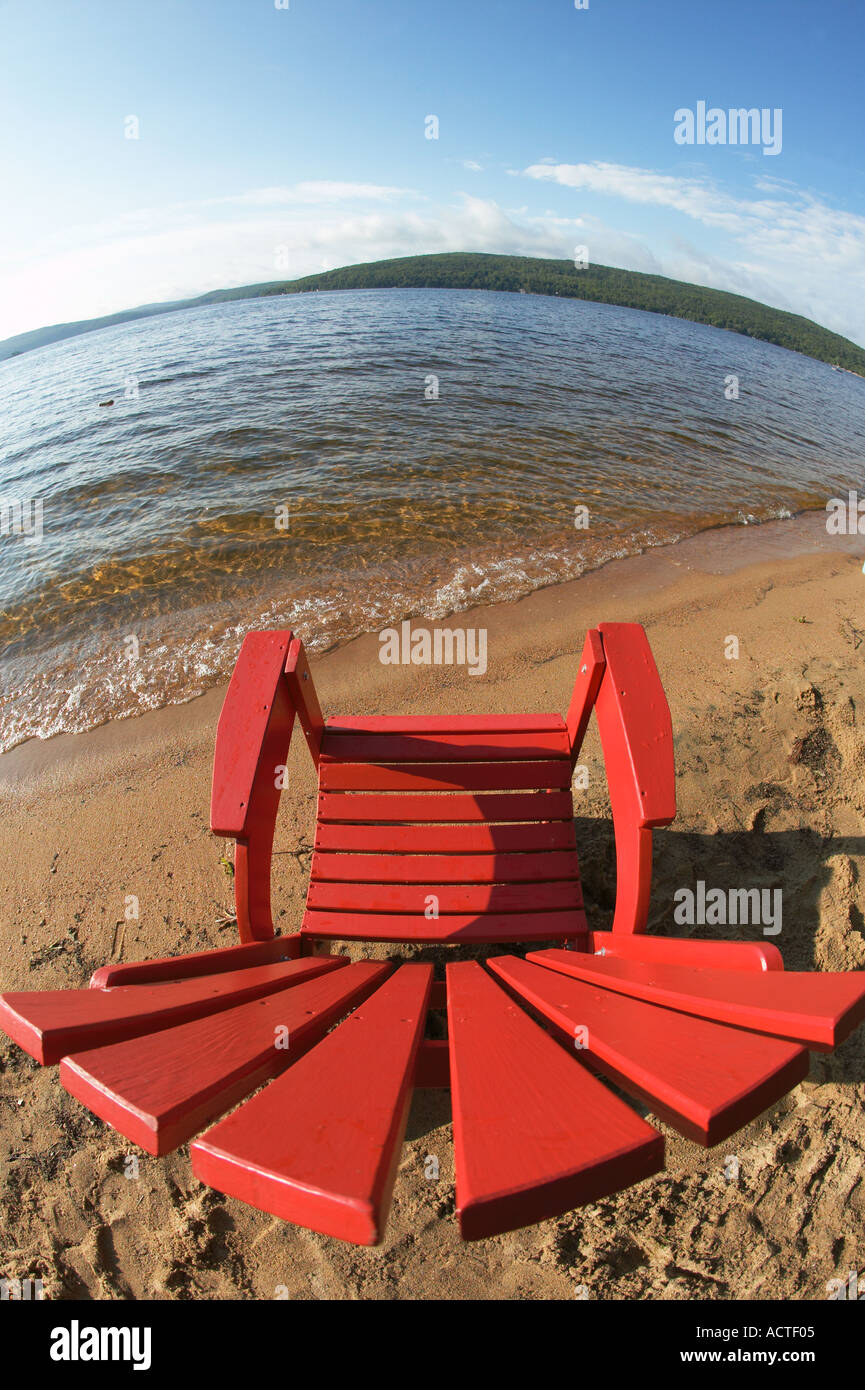 Adirondack chair on peaceful lake beach Stock Photo - Alamy