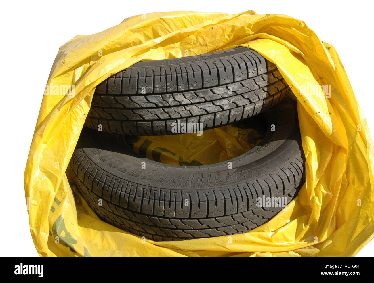 Two tyres in yellow bag on white Stock Photo - Alamy