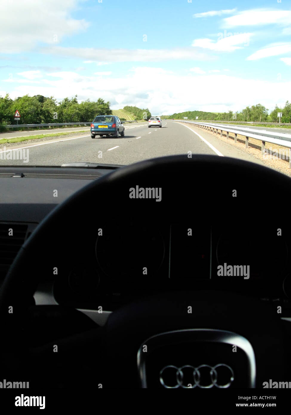 A portrait format image looking out of the front window of a car ...