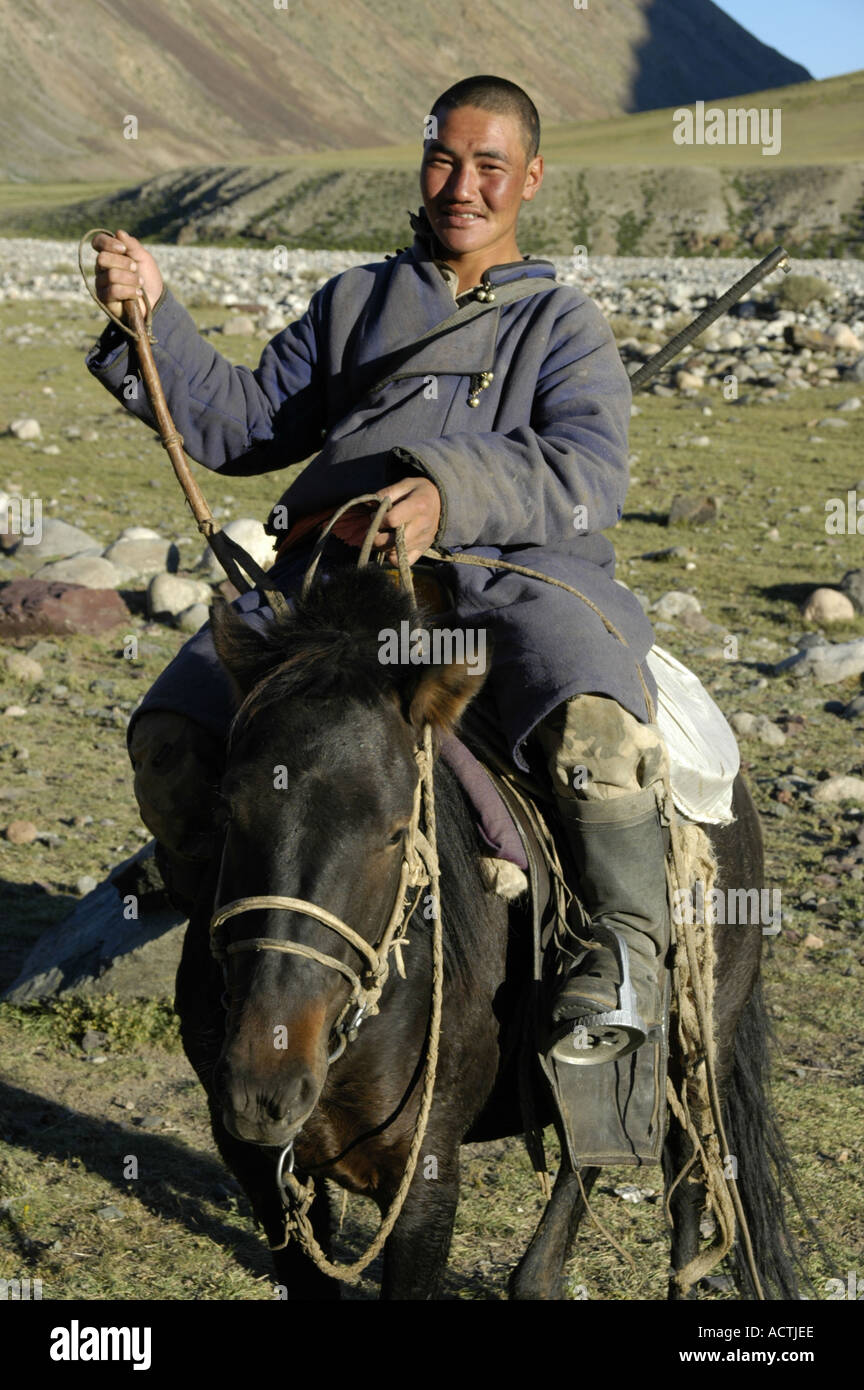Nomads young man dressed in traditional coat with a gun sits on his ...