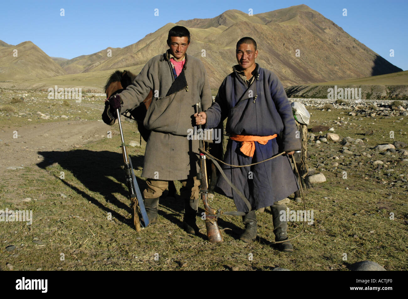 Nomads young men dressed in traditional coats with guns are standing in ...