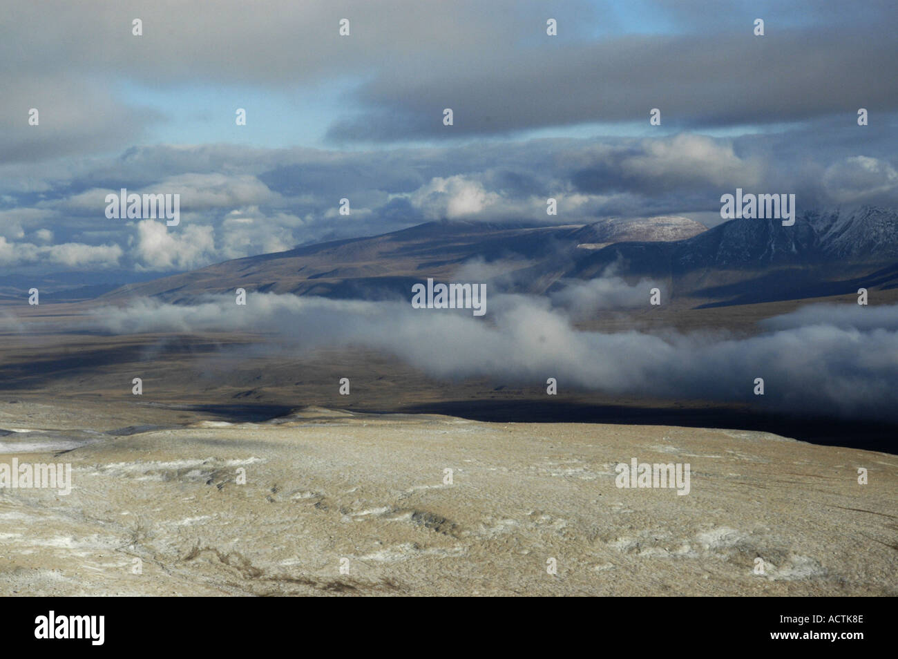 Fresh snow with dark clouds on mountains and steppe Kharkhiraa ...