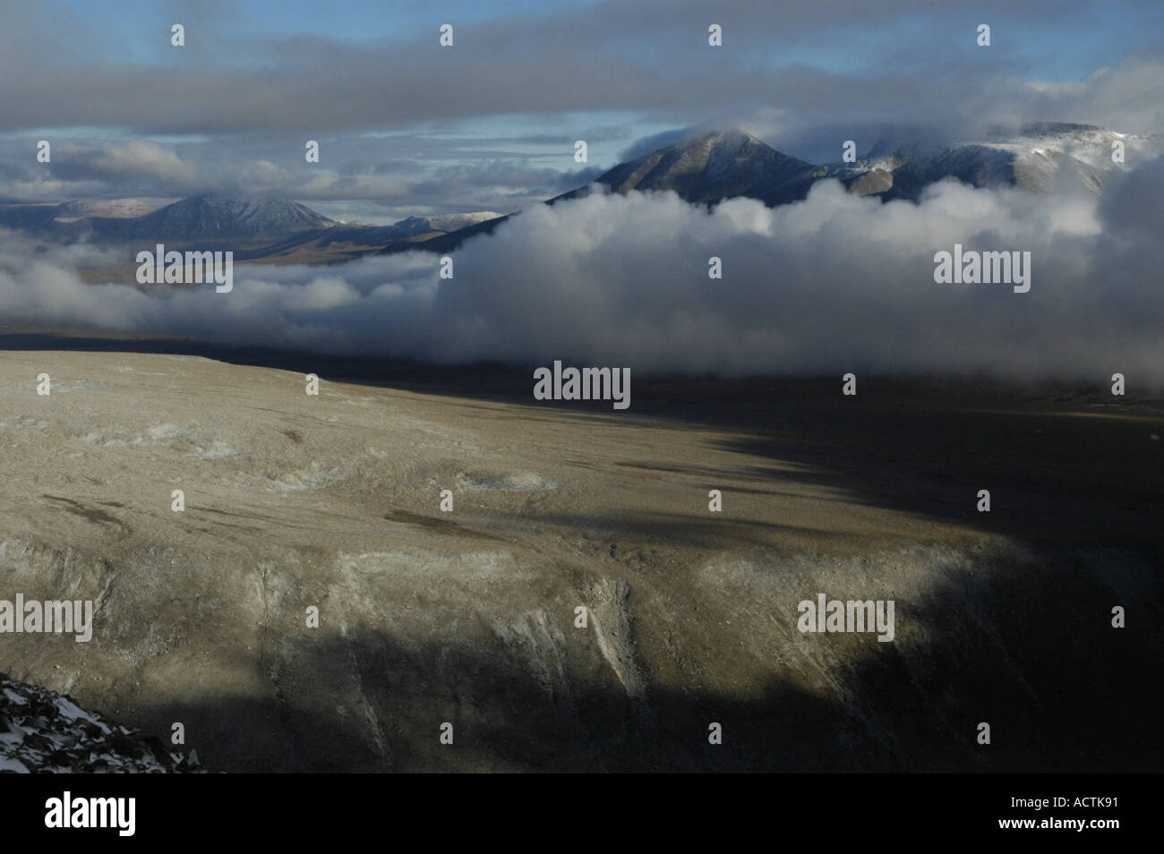 Fresh snow with clouds sun and shadow on mountains and steppe ...