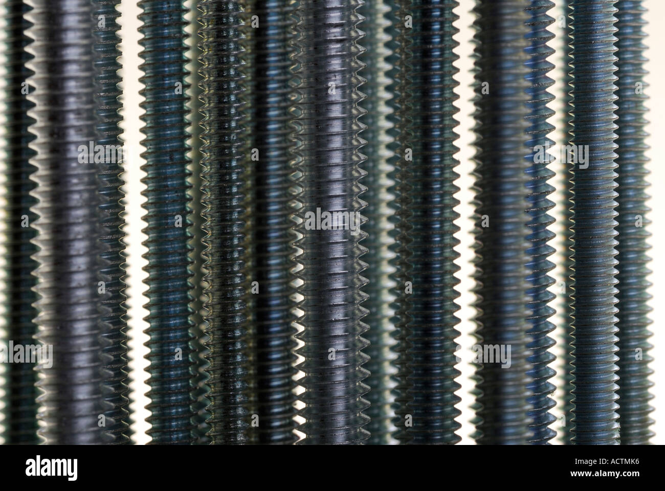 Abstract close up of a variety threaded metal bolts on white background ...