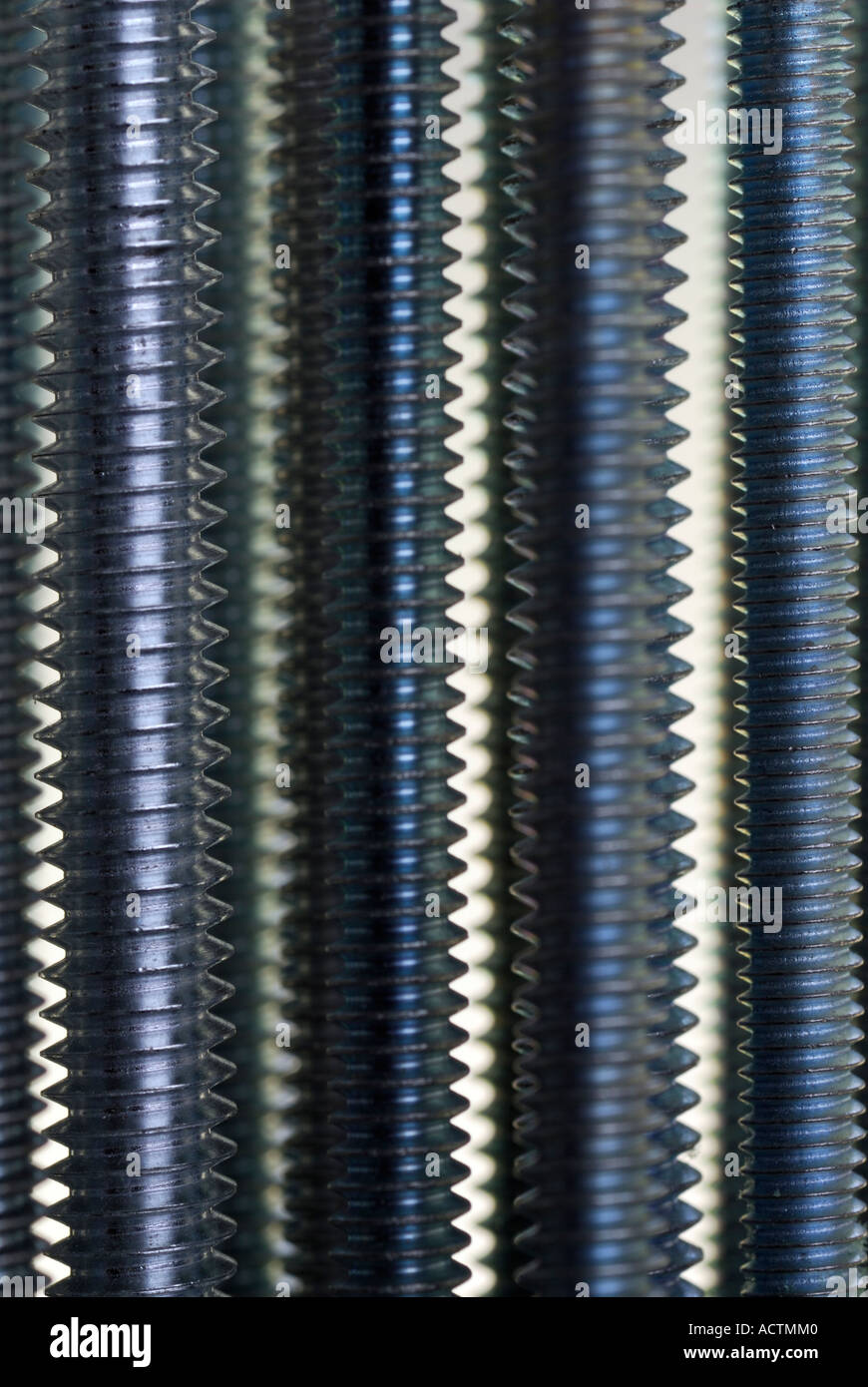 Portrait close up of a variety threaded metal bolts on white background ...