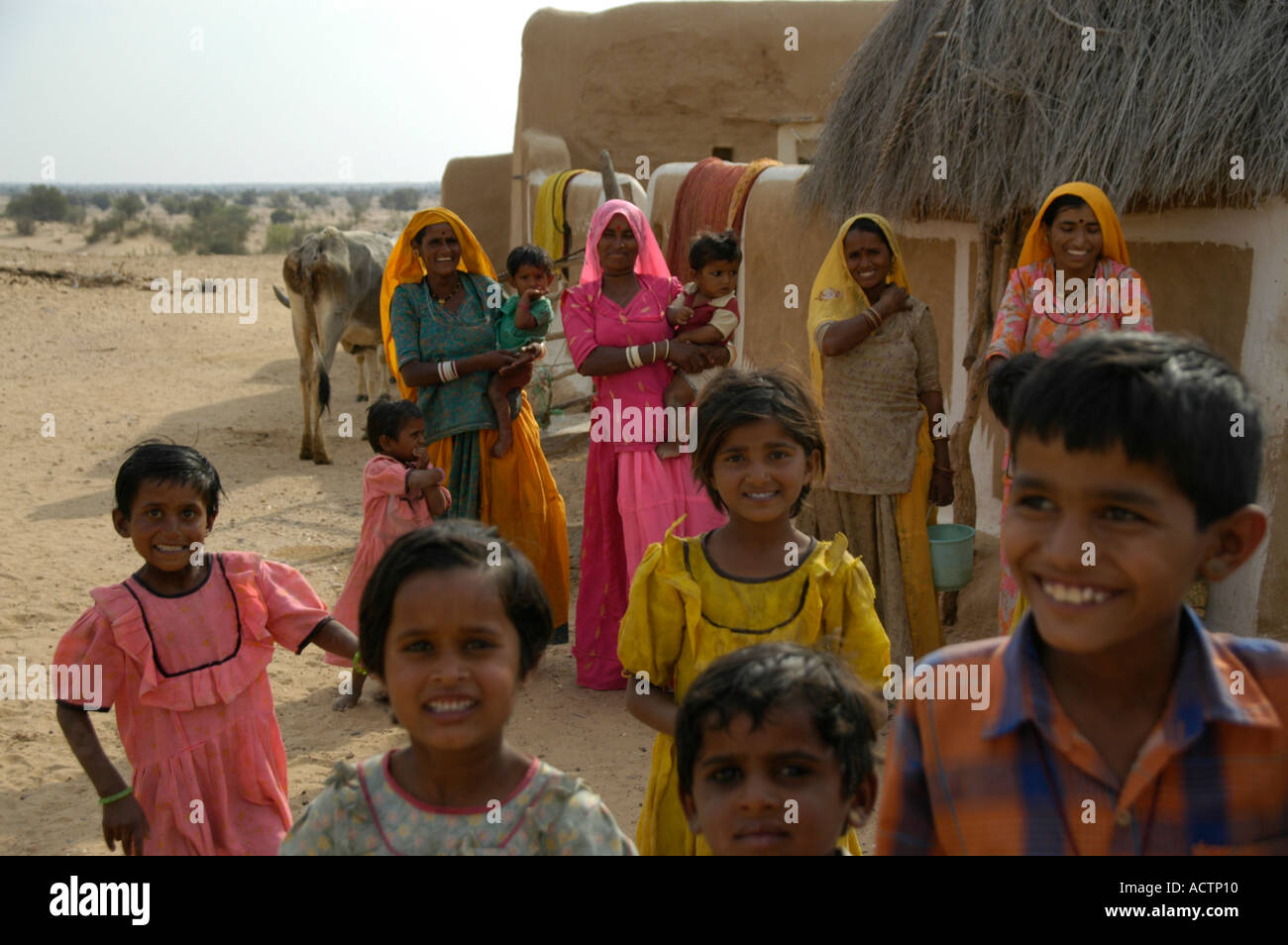 Many children and women in colourful sari in a village Thar desert near ...