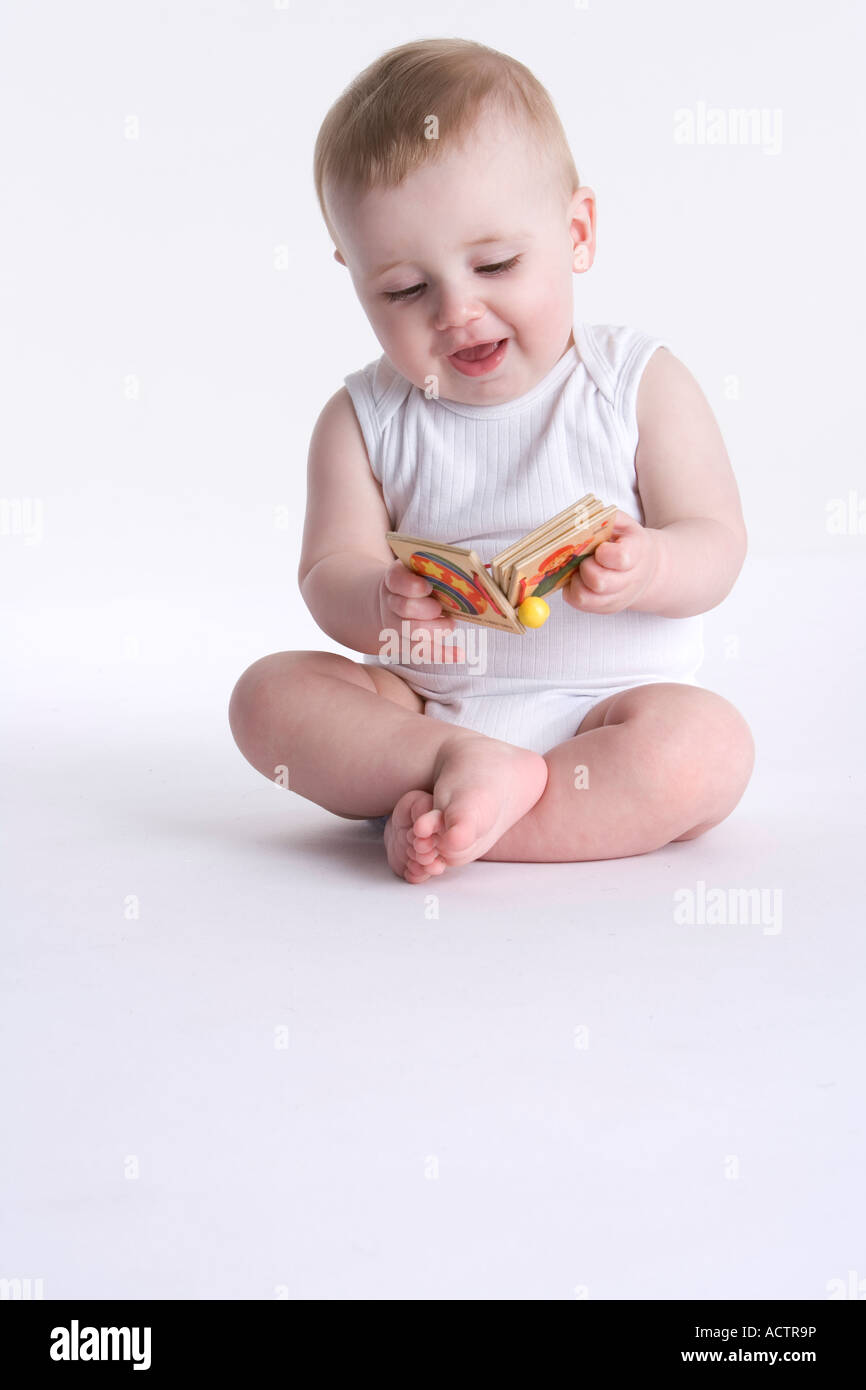 Baby boy reading a wooden toy book Stock Photo - Alamy