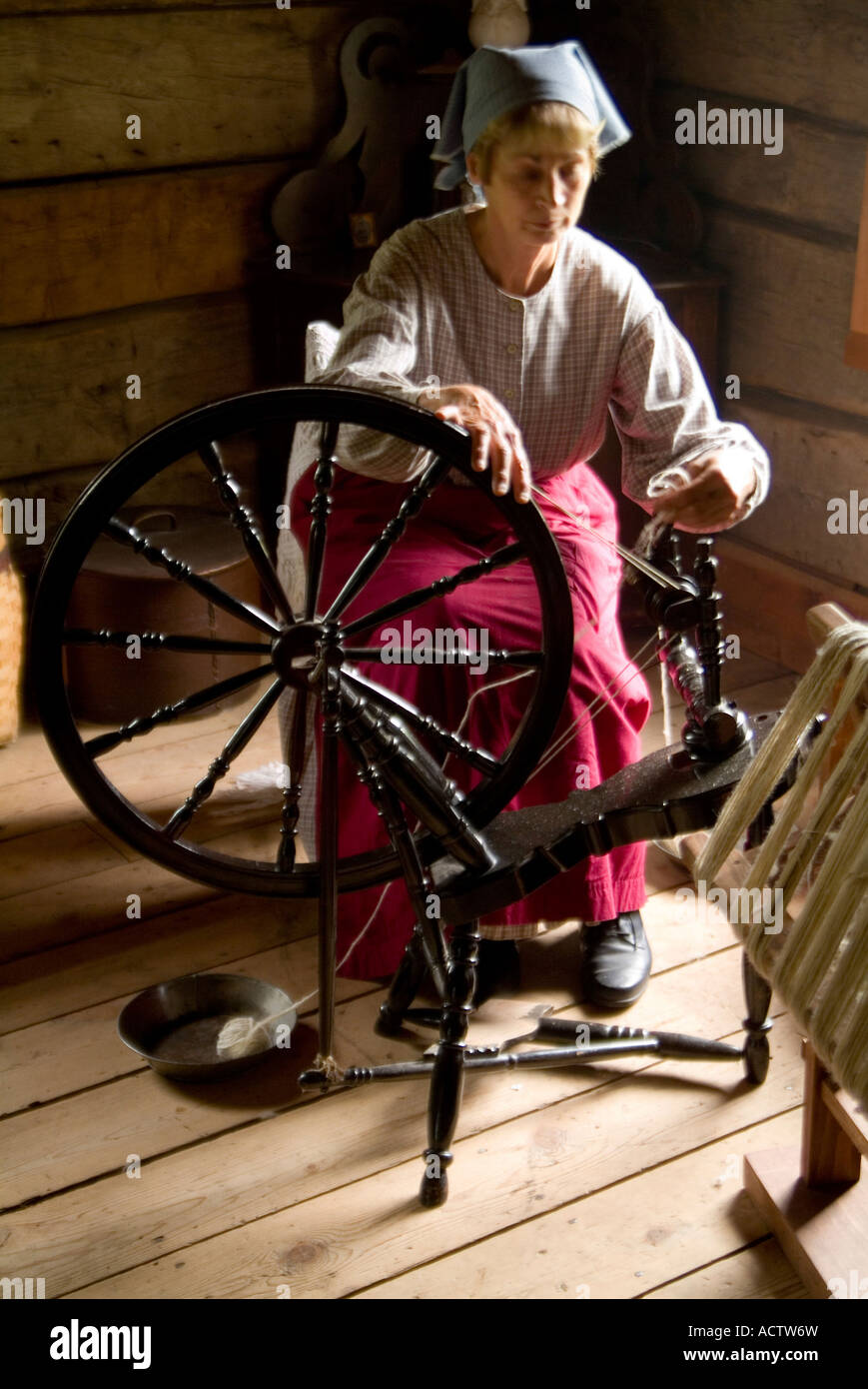 A WOMAN DRESSED IN RAGS AND A HEAD SCARF IS SPINNING YARN ON HER ...