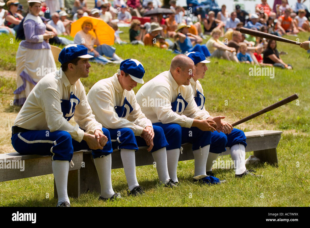 BASEBALL TEAM DRESSED IN WORLD WAR II ERA UNIFORMS ARE SITTING ON THE ...