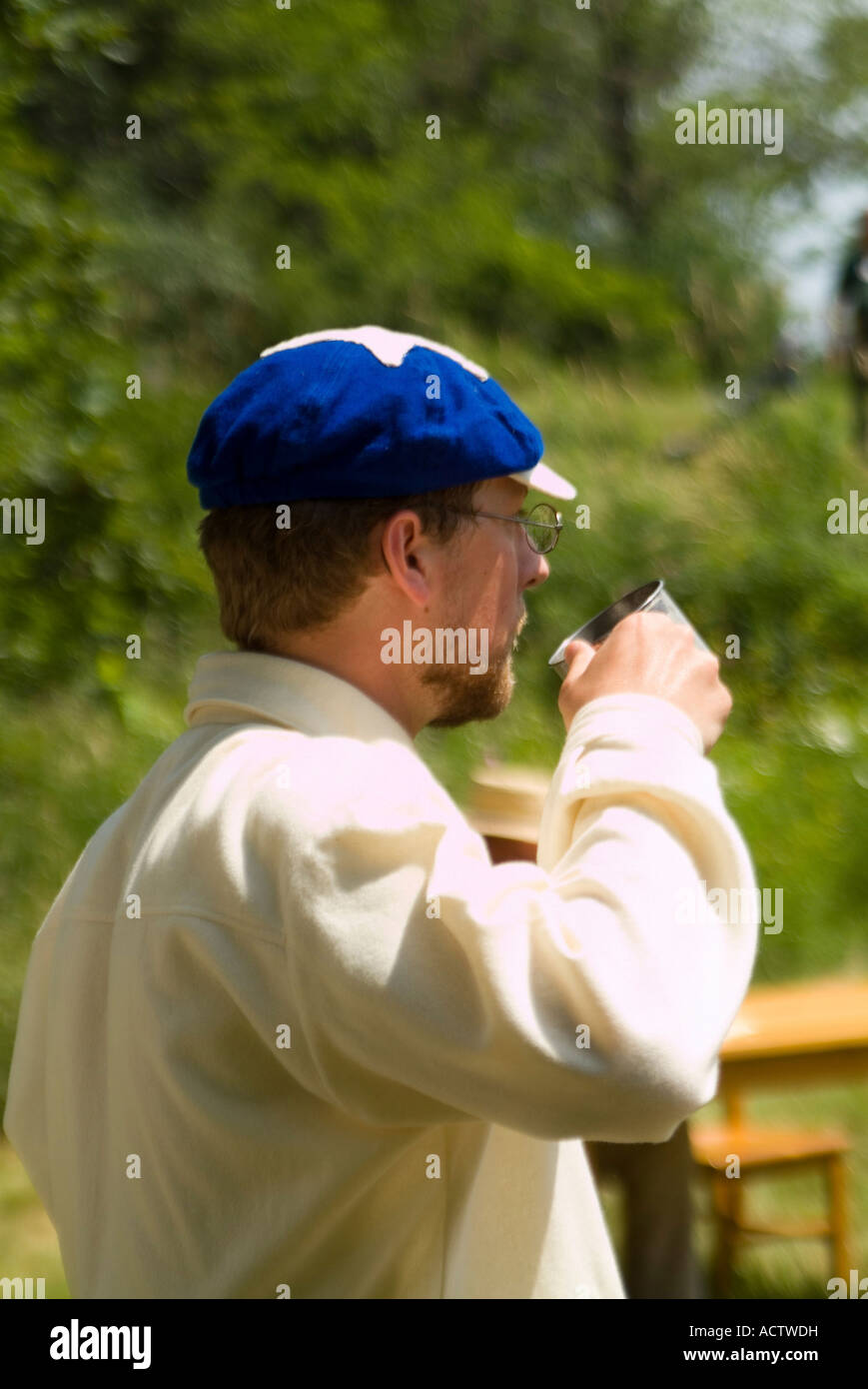 A BASEBALL PLAYER DRESSED IN WORLD WAR II ERA COSTUME IS DRINKING WATER ...