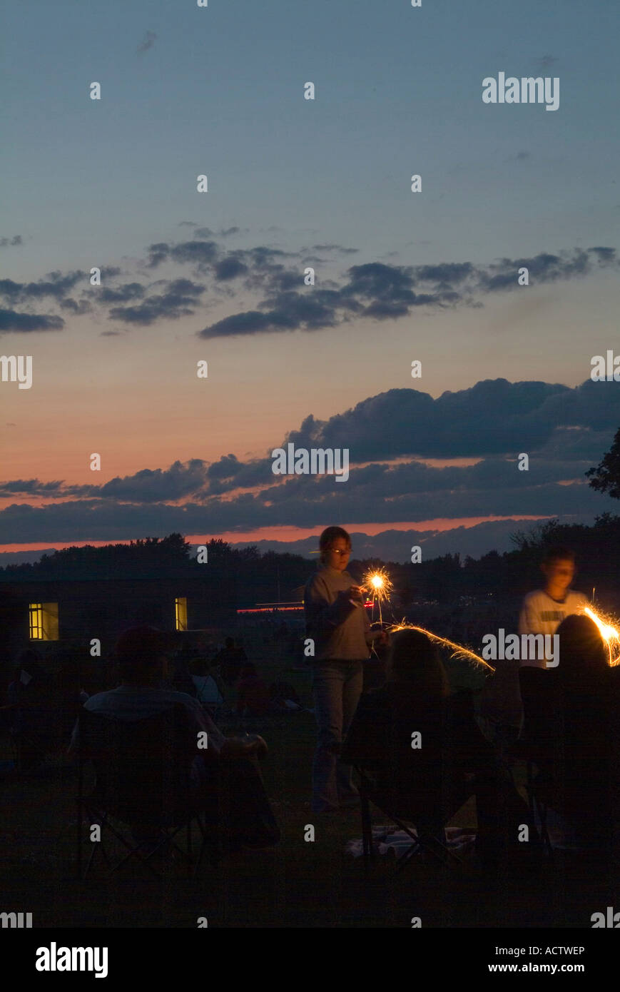 KIDS ARE LIGHTING THEIR OWN FIRE CRACKERS AT DUSK IN THE PRECURSOR OF ...