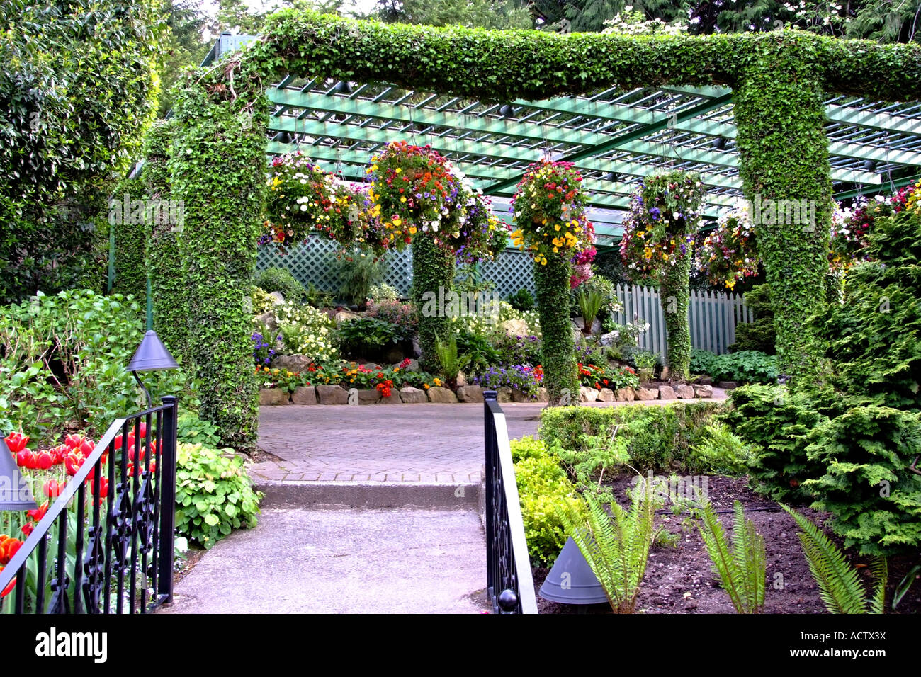 FOOTPATH LEADING TO CANOPY OF FLOWERS AND BUSHES AT BUCHART GARDEN ...